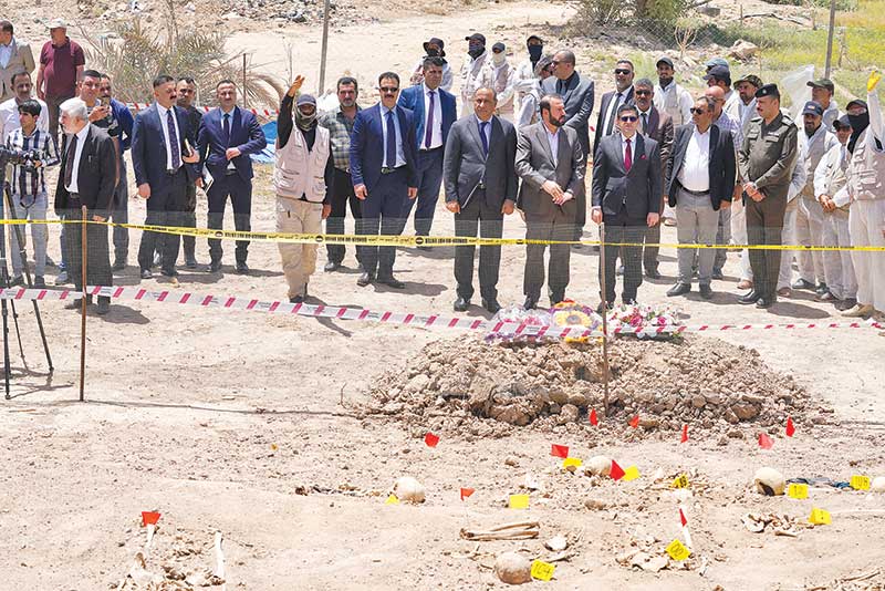 Iraqi officials visit a mass grave where human remains were exhumed
